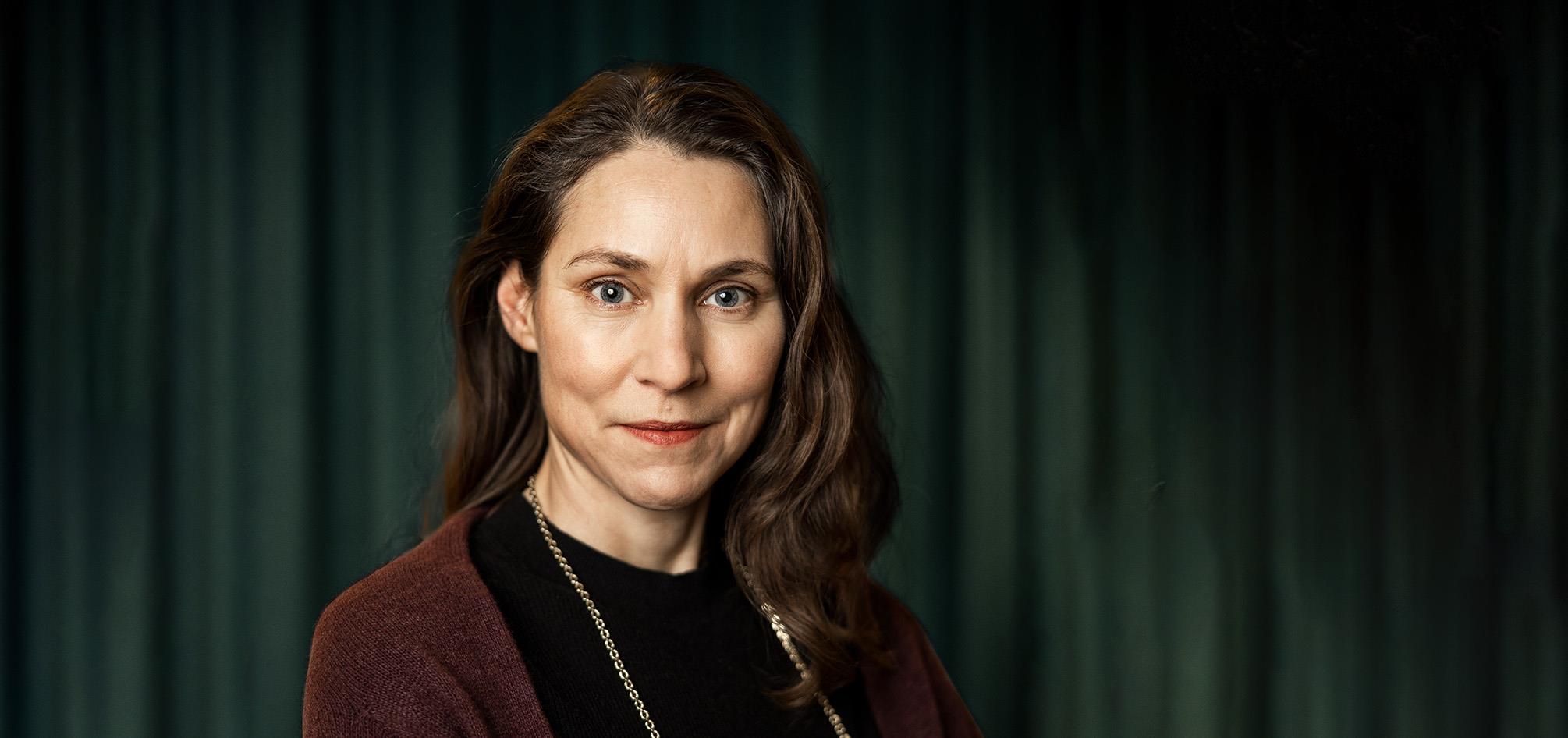 Emma Henriksson framför grönt draperi